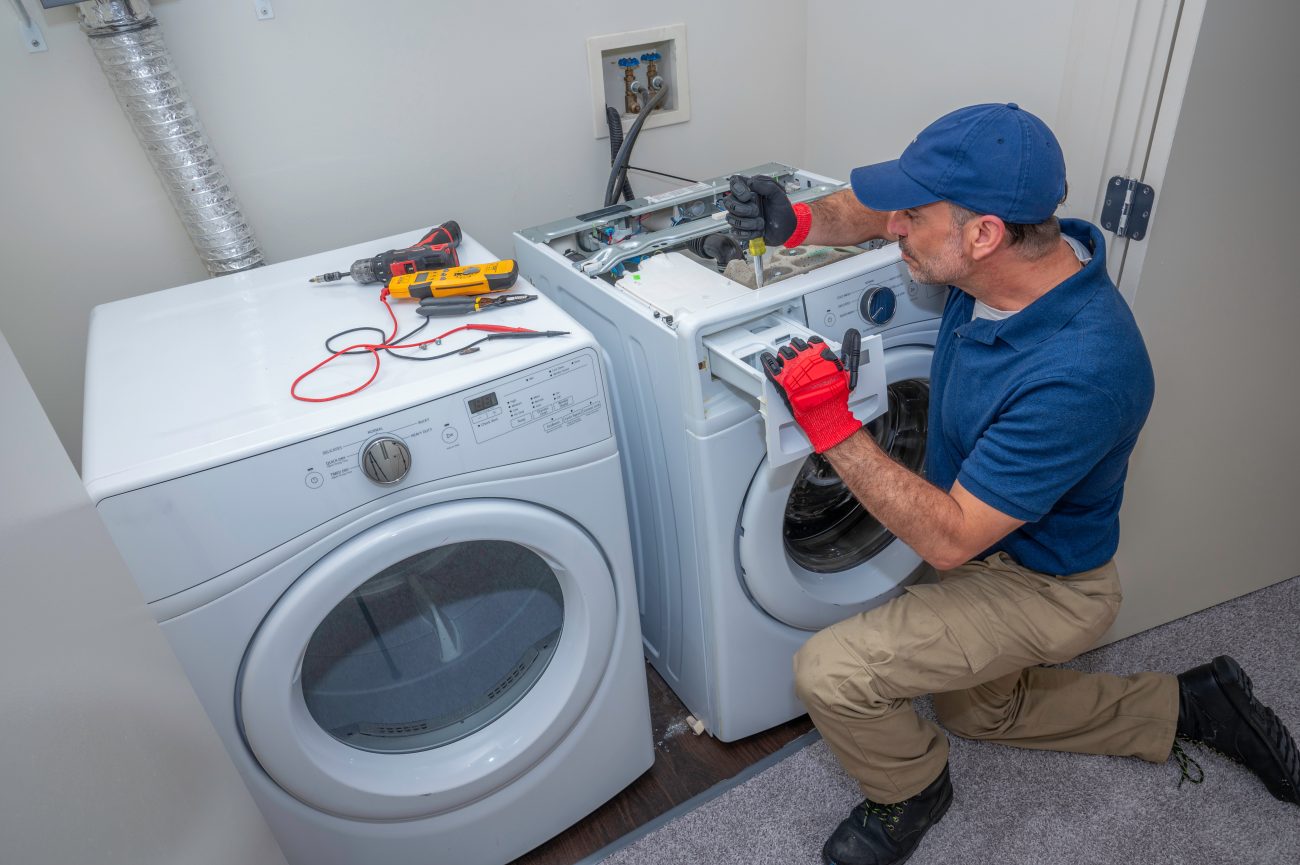 Appliance technician working on a front load washing machine in a ...